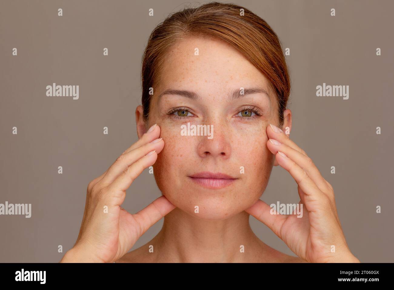 Portrait of middle aged woman face with freckles holding fingers on cheeks Stock Photo - Alamy