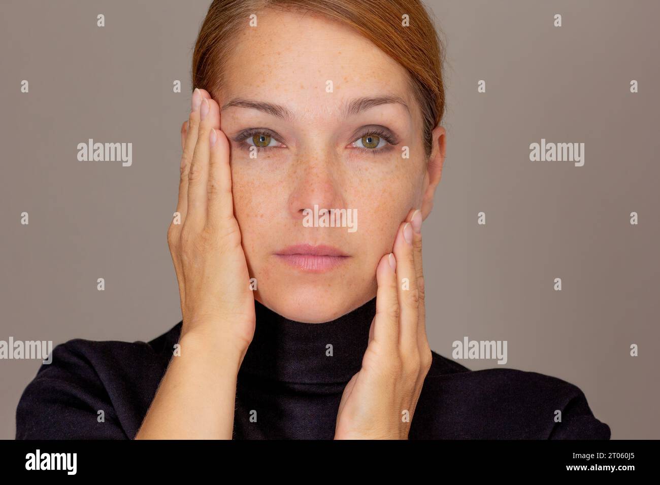 Portrait of looking at camera holding palms on cheeks showing of soft ...