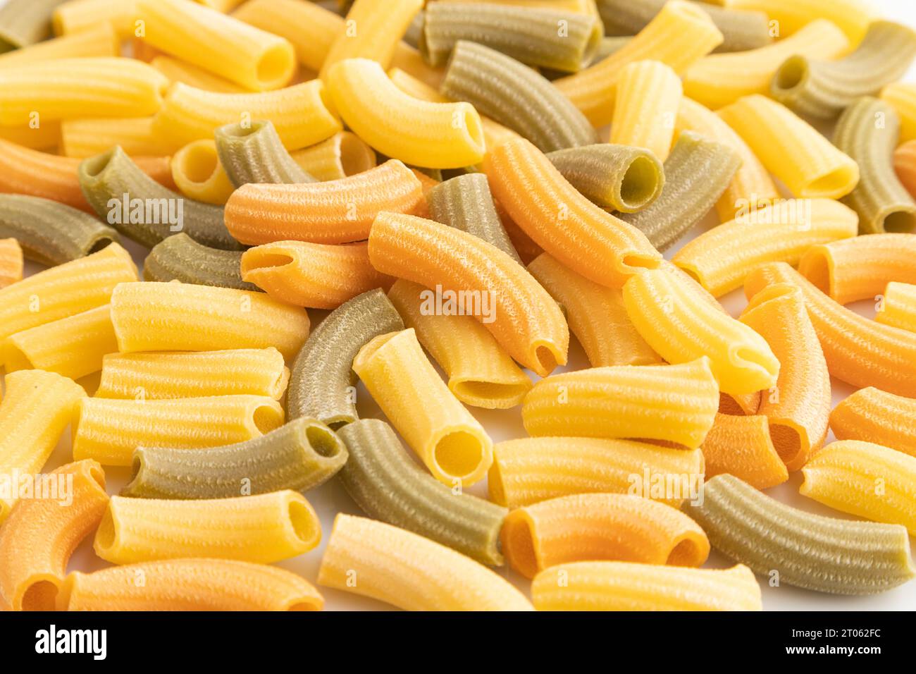 Rigatoni colored raw pasta, texture, background. Side view Stock Photo ...