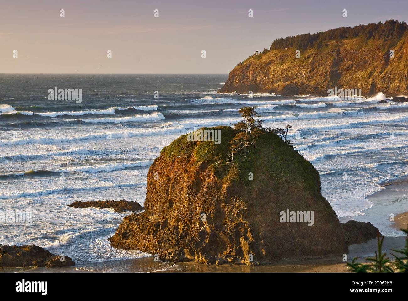 Rock on beach, lighthouse at Cape Meares in distance at Three Capes ...