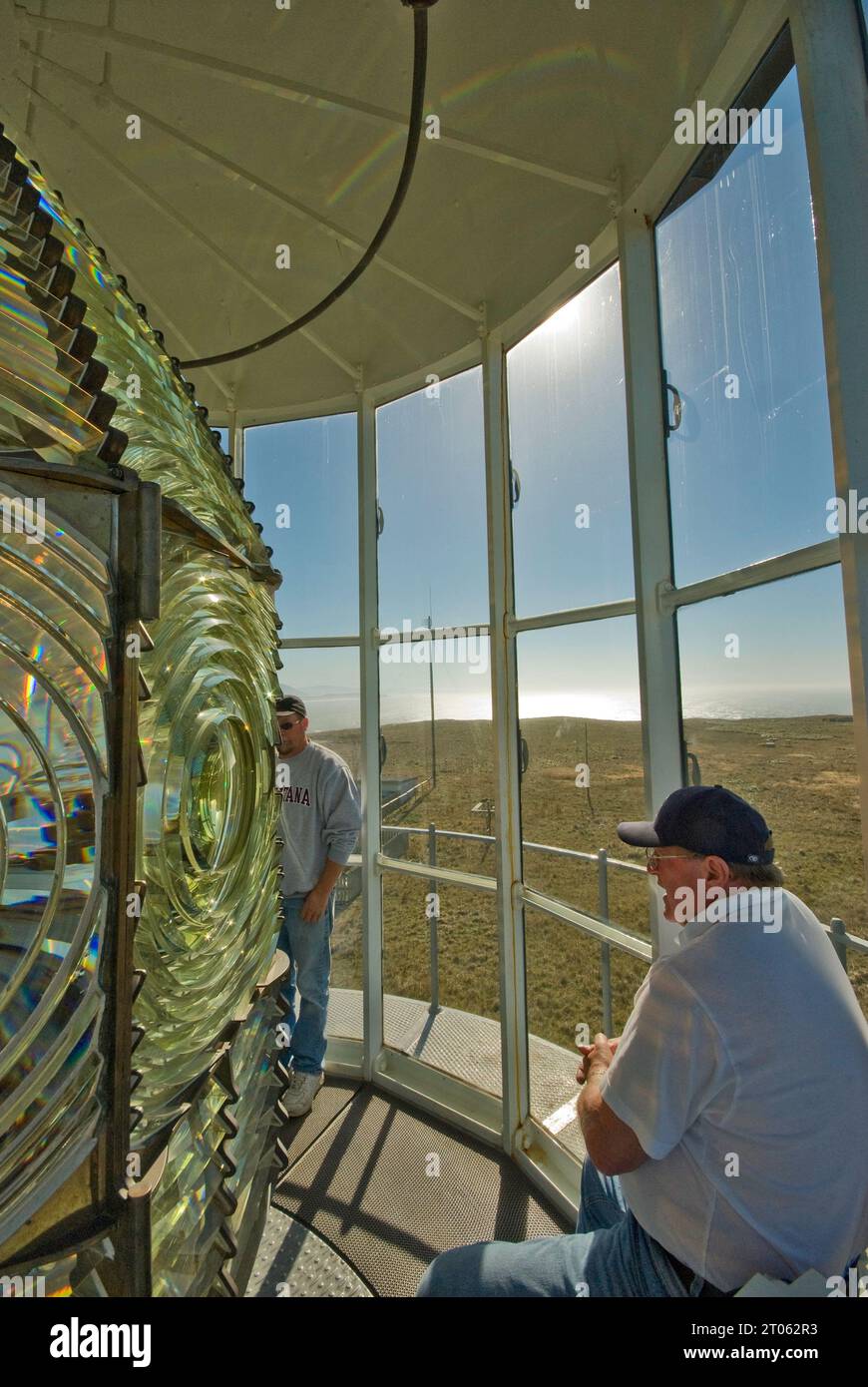 Fresnel lens, interpreter and visitor at Cape Blanco Lighthouse near Port Orford, Oregon, USA ...