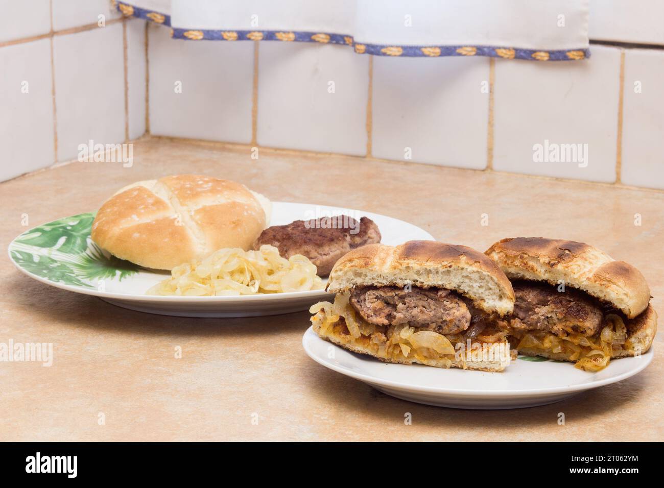 A prepared hamburger, cut in half to reveal its juicy homemade patty ...