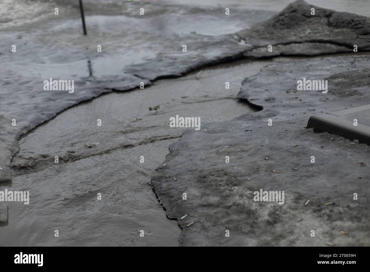 Dirty water flows on asphalt. Flow of water along road. Cloudy liquid ...