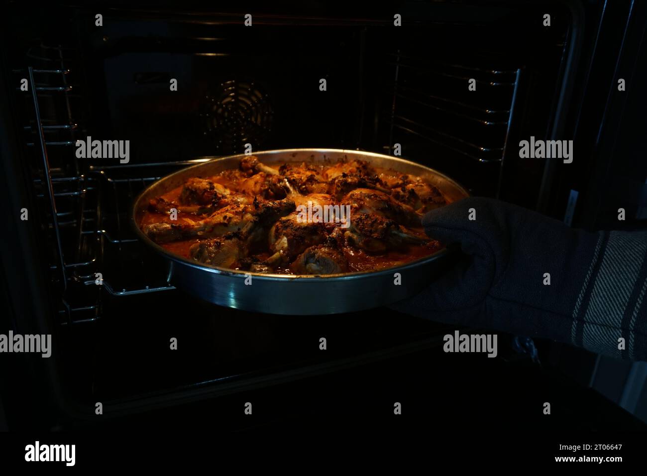 oven-baked chicken dish.taking food out of the oven Stock Photo - Alamy