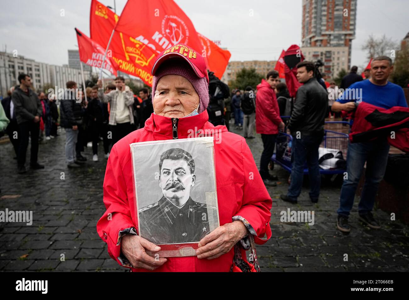 An elderly woman holds a portrait of aSoviet leader Josef Stalin as ...