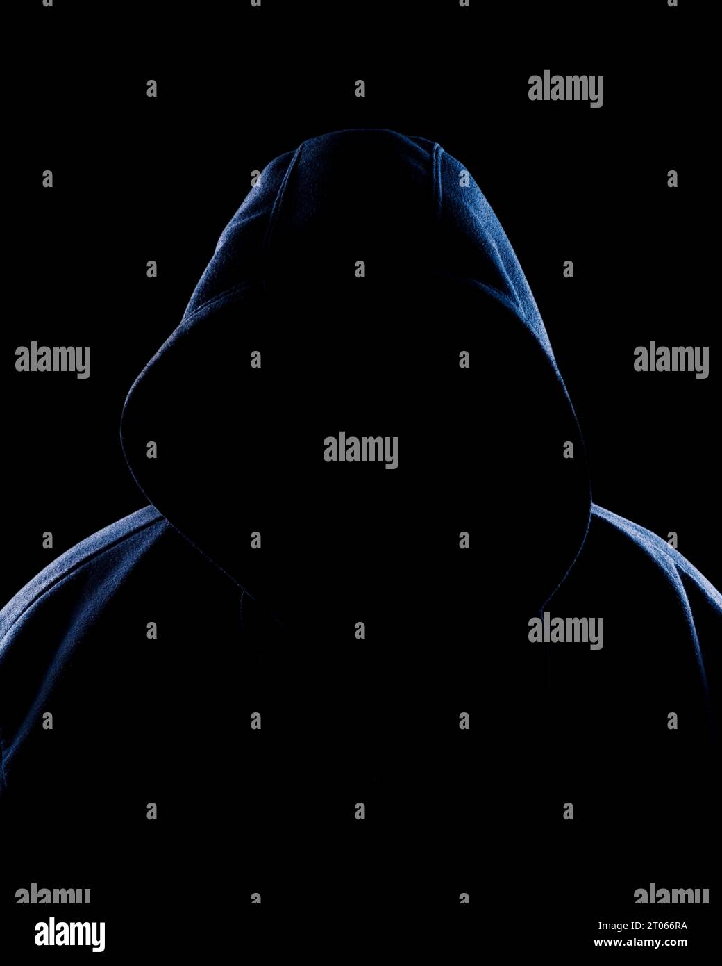 Hooded figure looming from darkness Stock Photo - Alamy