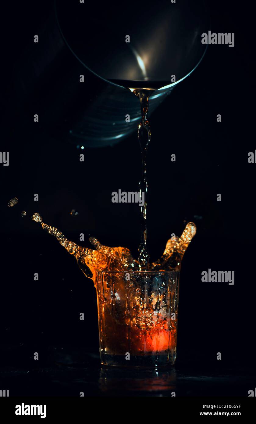 Pouring tea from a cup to glass, Splashing Stock Photo - Alamy
