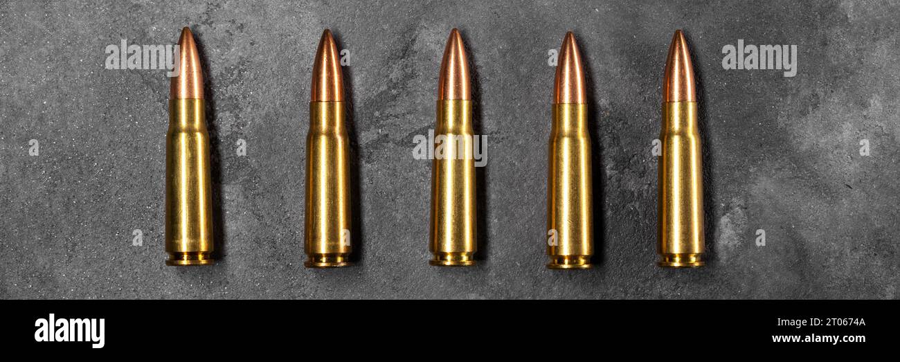 Bullets for Kalashnikov assault rifle on gray concrete and gradient ...