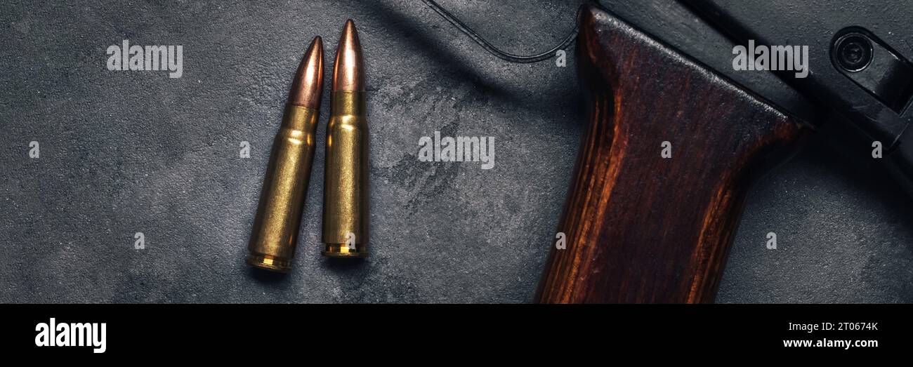 Two bullets for Kalashnikov assault rifle on gray concrete and gradient ...