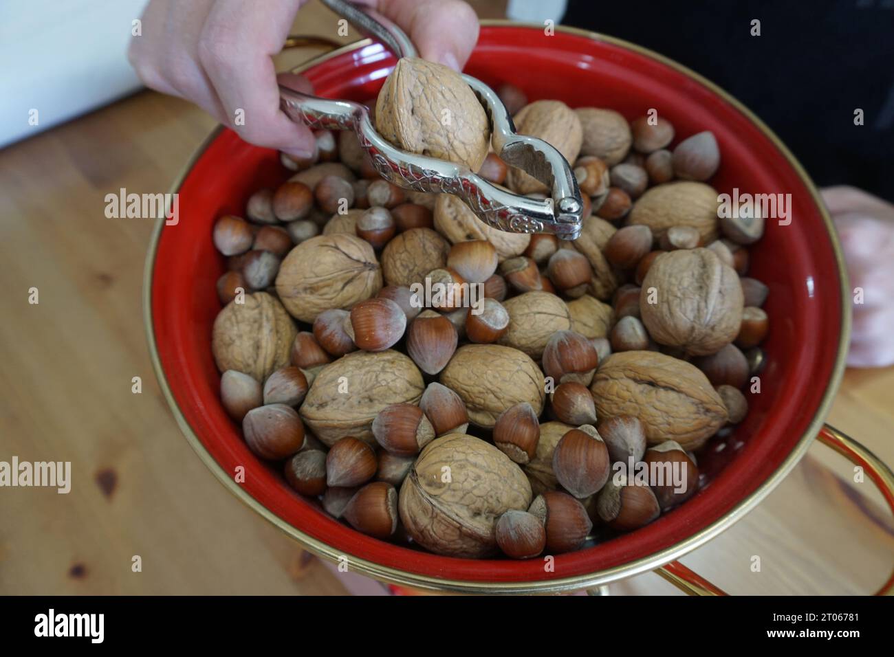Cracking the walnuts and hazelnuts in the bowl. Cracking walnuts with a ...
