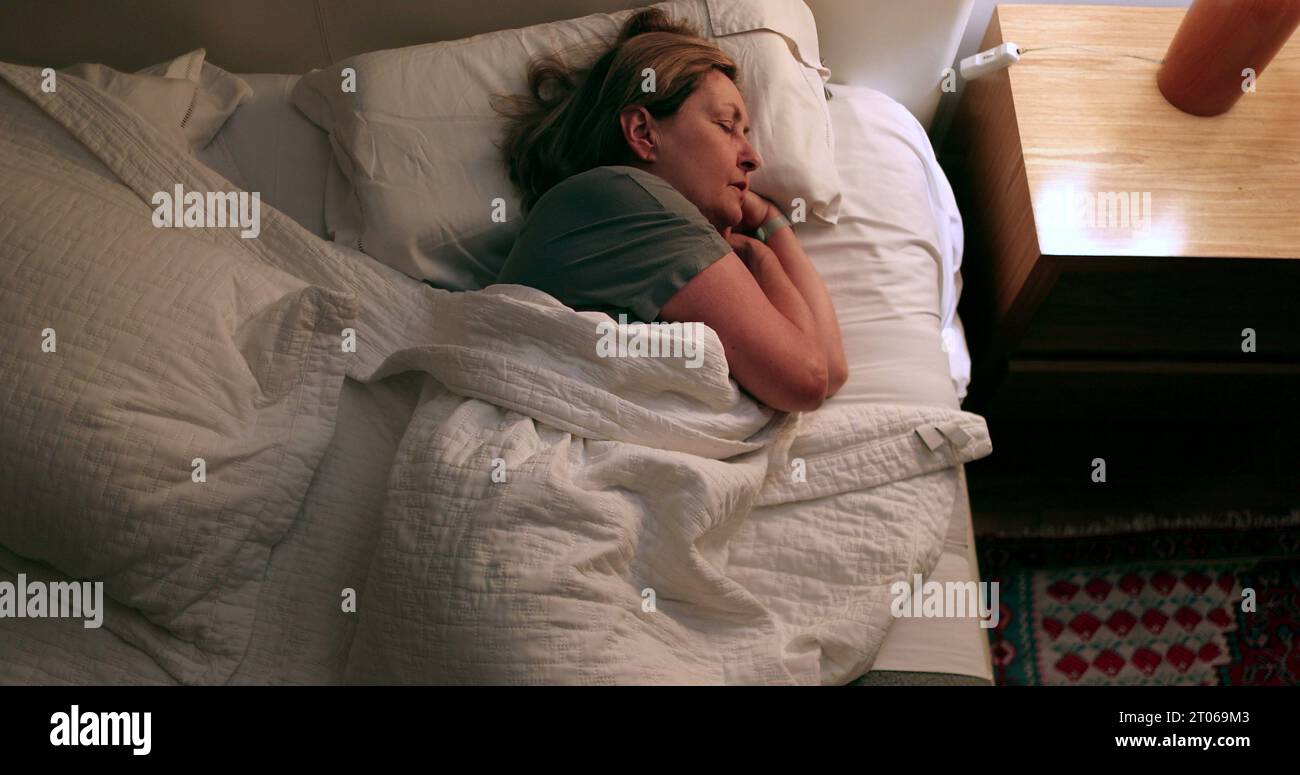 Anxious woman unable to sleep turns on light on, tossing and turning in bed Stock Photo - Alamy
