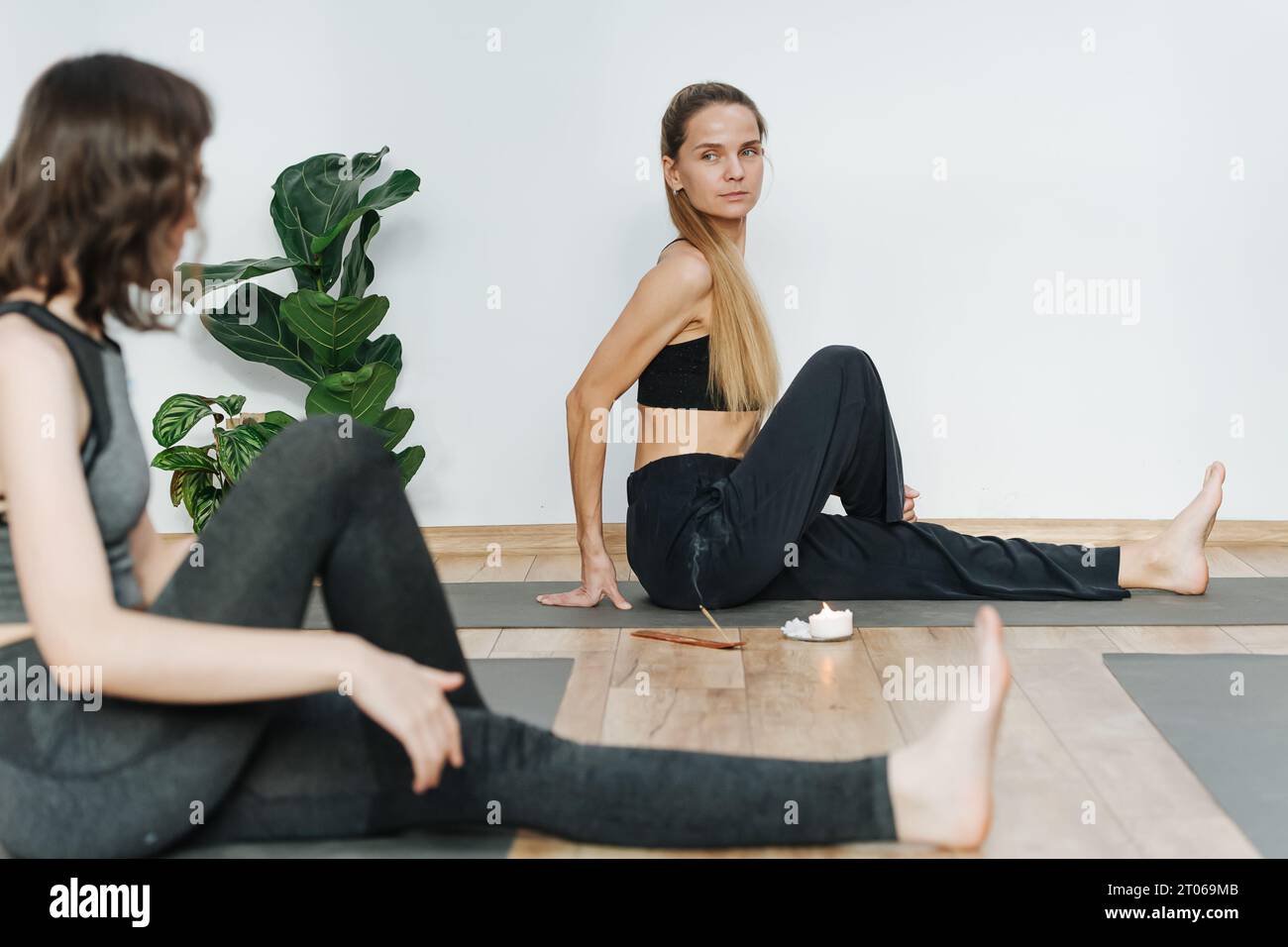 A woman repeating the body position after the teacher during yoga ...