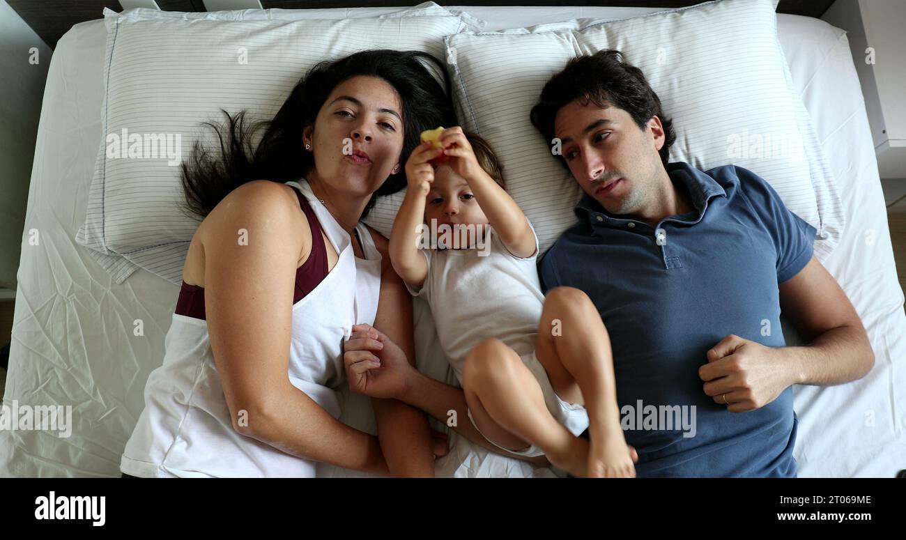 Joyful parents with baby infant in bed interaction, happy loving ...