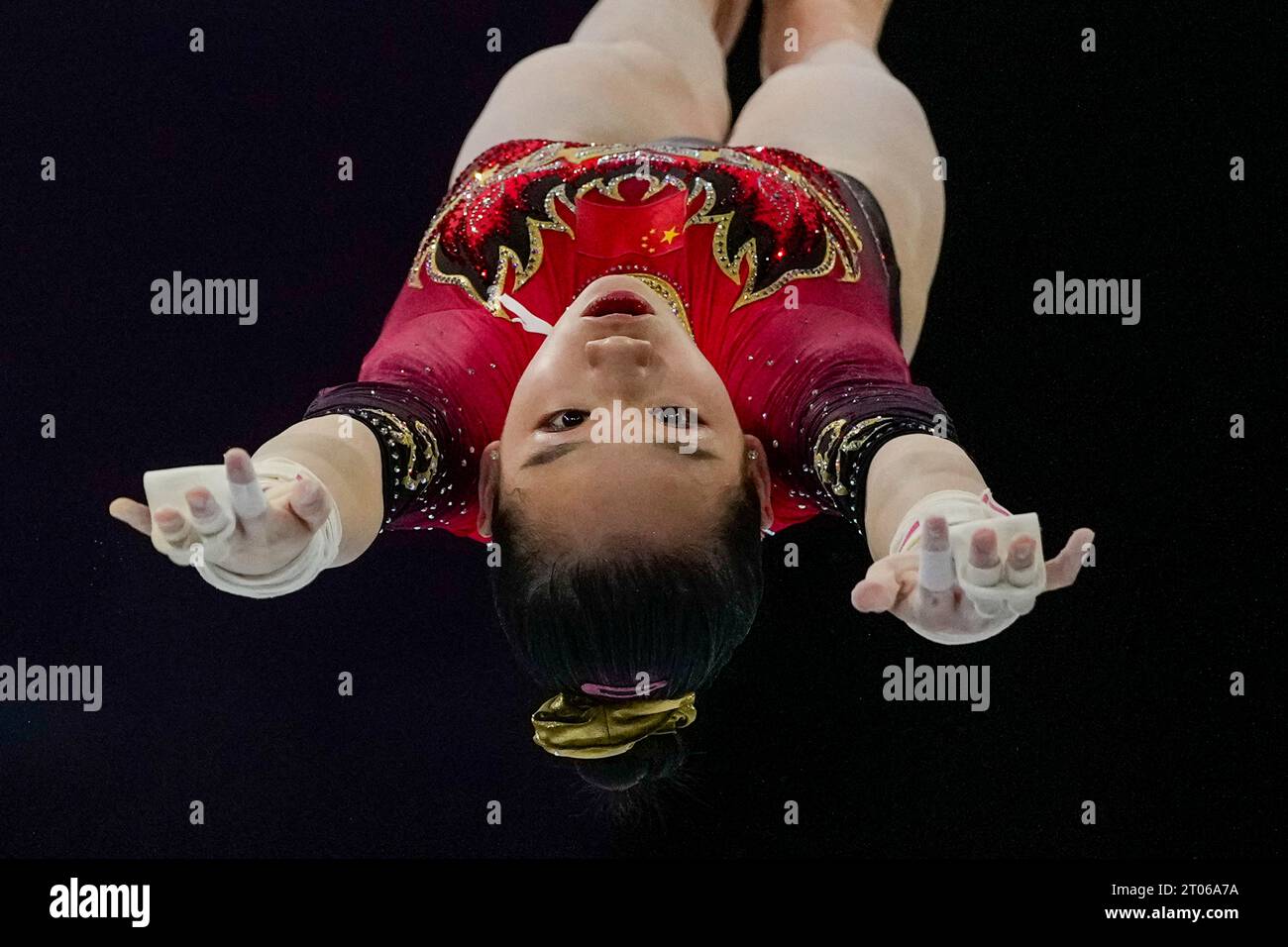 China's Ou Yushan competes on the uneven bars during the women's team ...