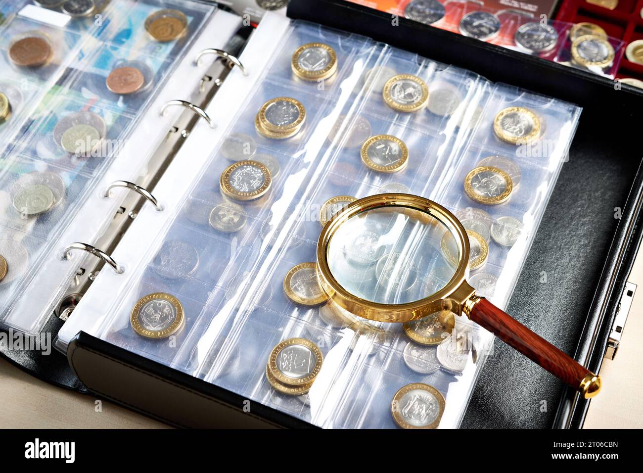 Collecting coins numismatics. Album with magnifying glass Stock Photo ...