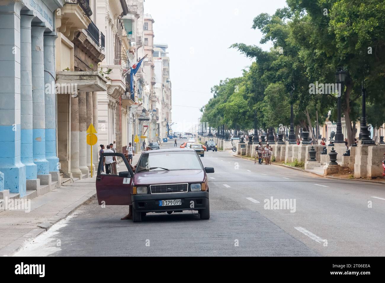 A car with an open door is in Paseo del Prado Avenue. The traditional ...