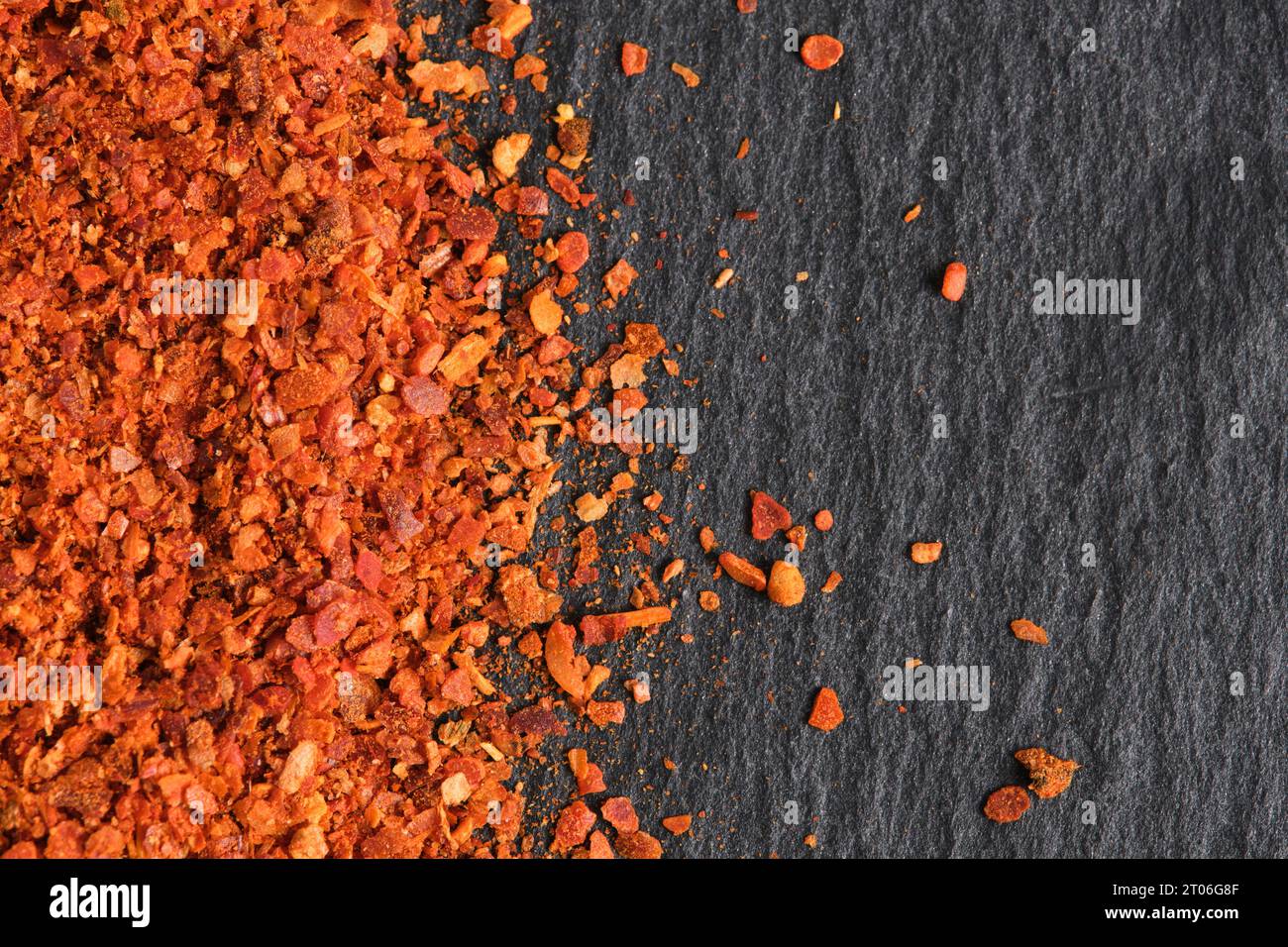 Macro background of red ground pepper. Against background slate stone ...