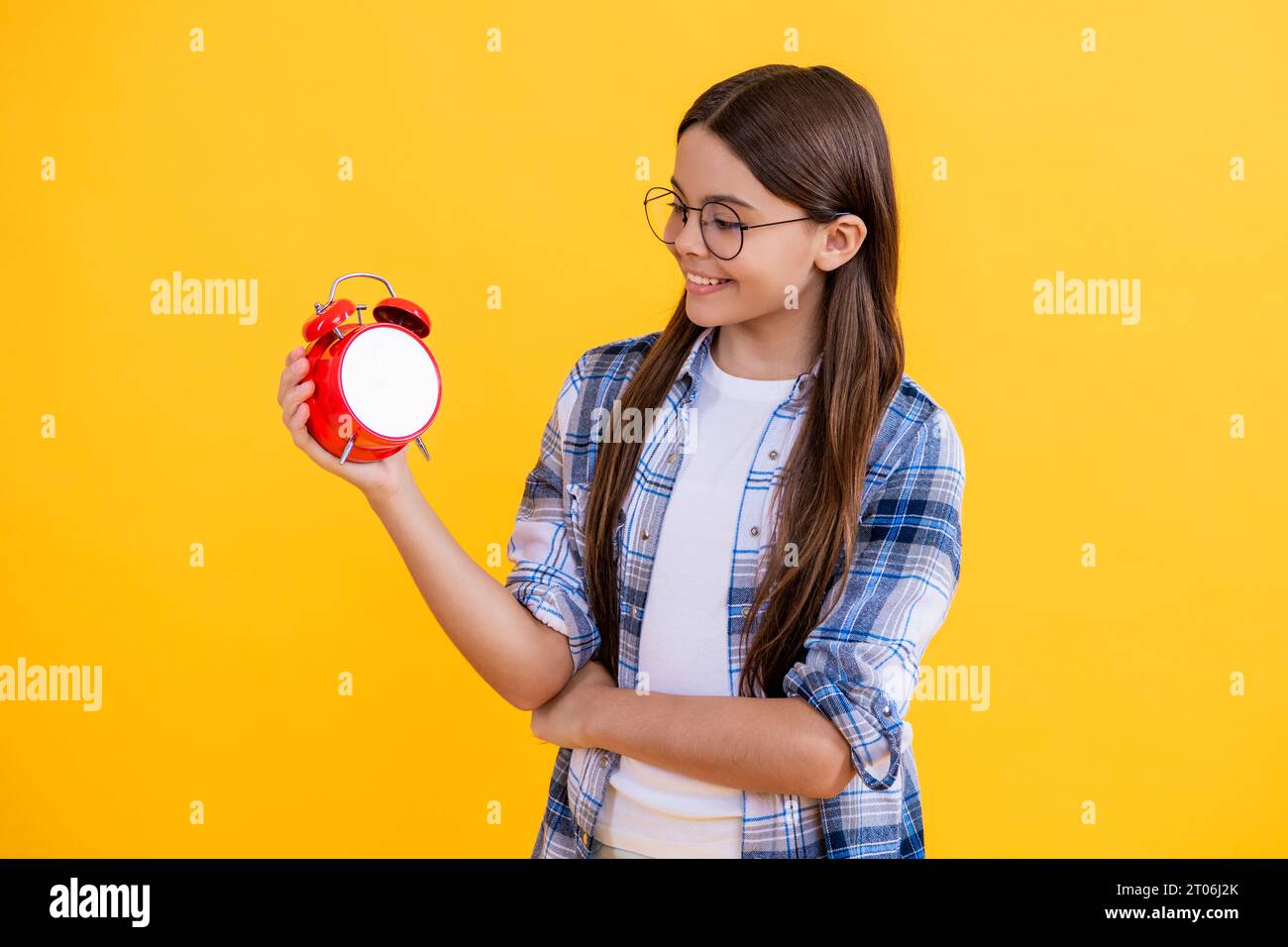 Teen girl organizing her schedule with a clock. Teen girl hold alarm ...