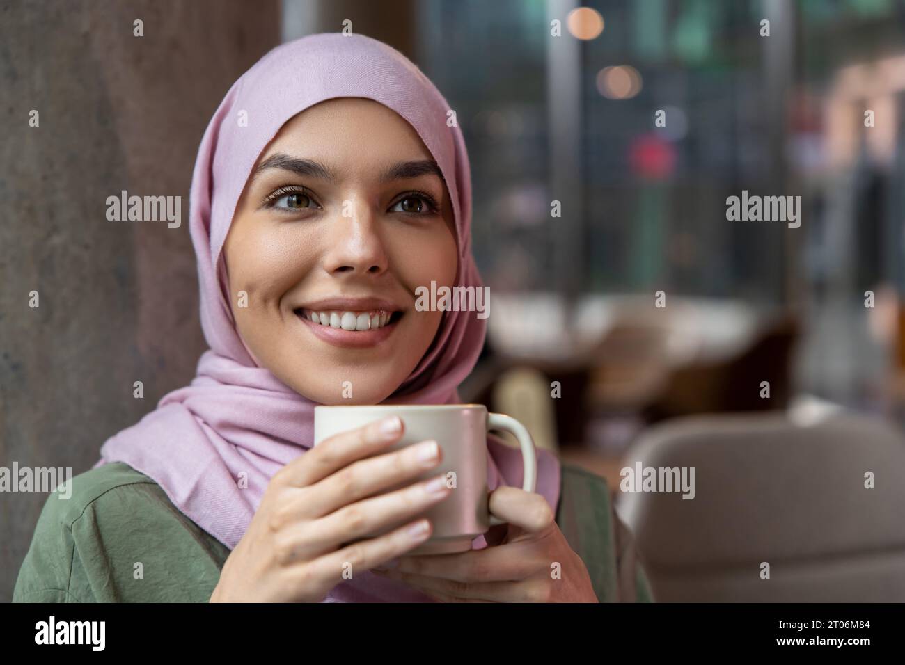 Pretty young smiling muslim woman enjoying her coffee Stock Photo - Alamy