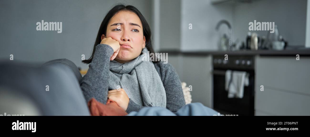 Image of sad young woman feeling sick, being unwell, sitting with scarf ...