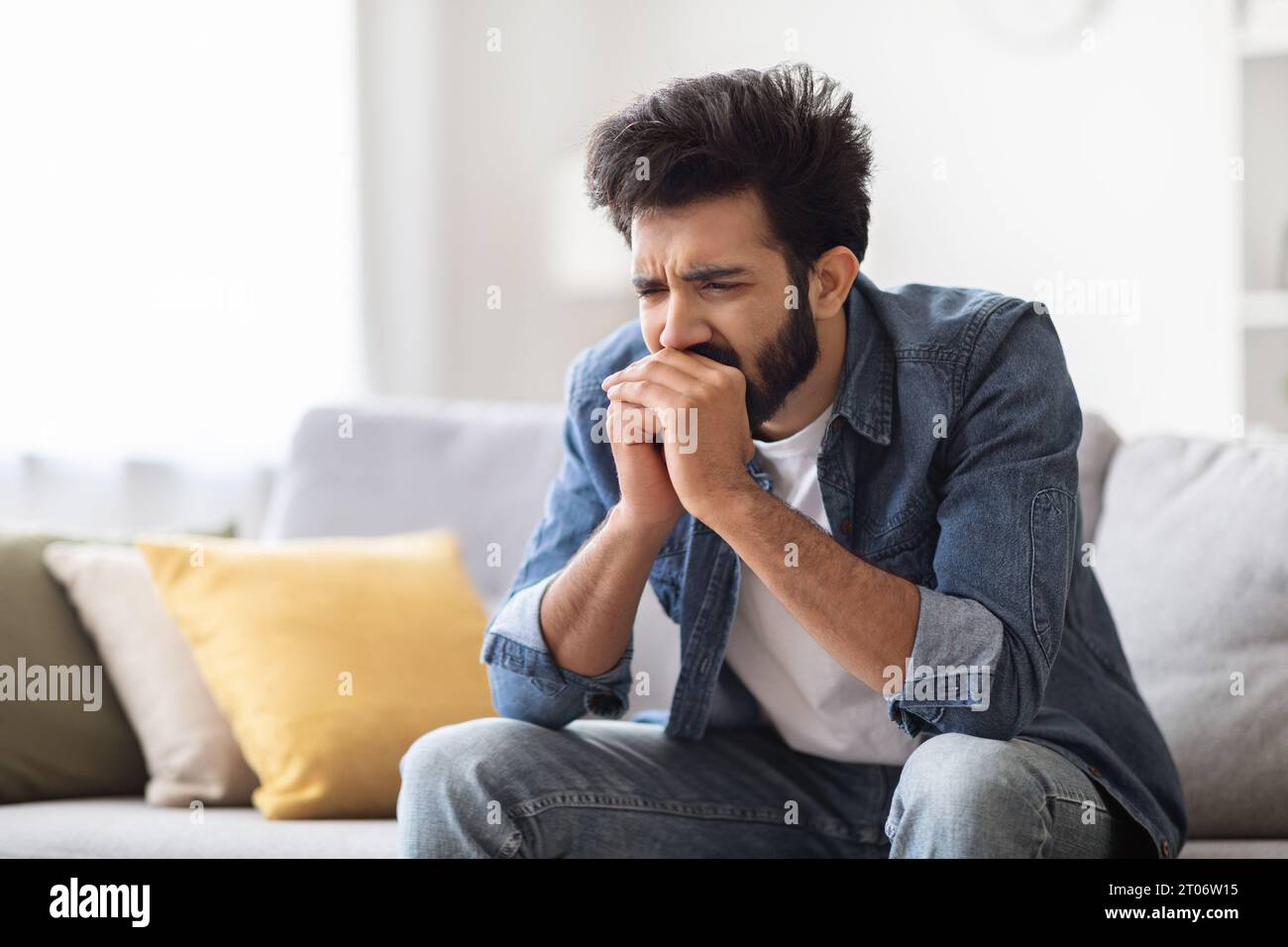 Portrait of stressed depressed young indian man sitting on couch at ...