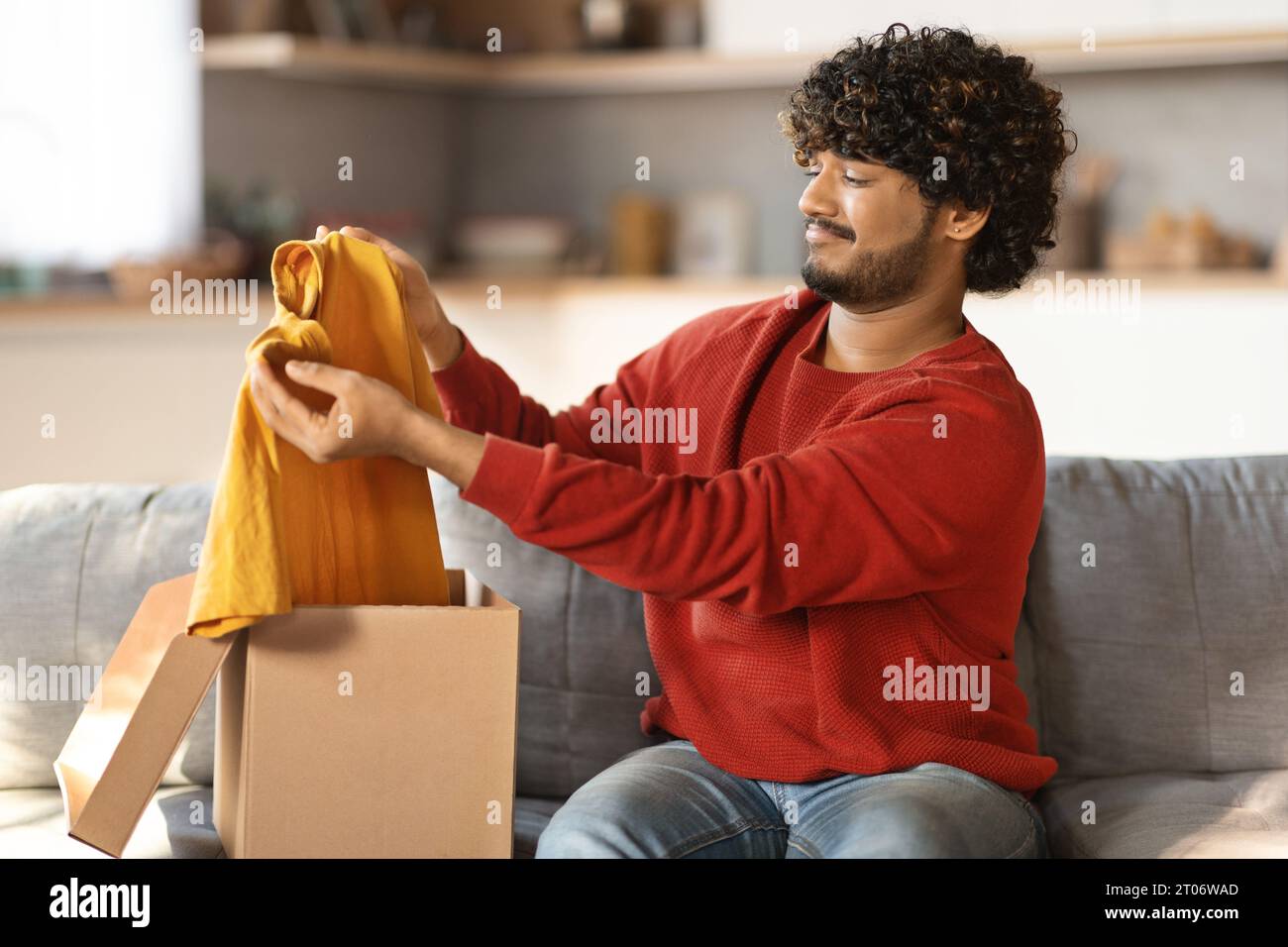 Bad delivery service concept. Dissatisfied indian man unpacking ...
