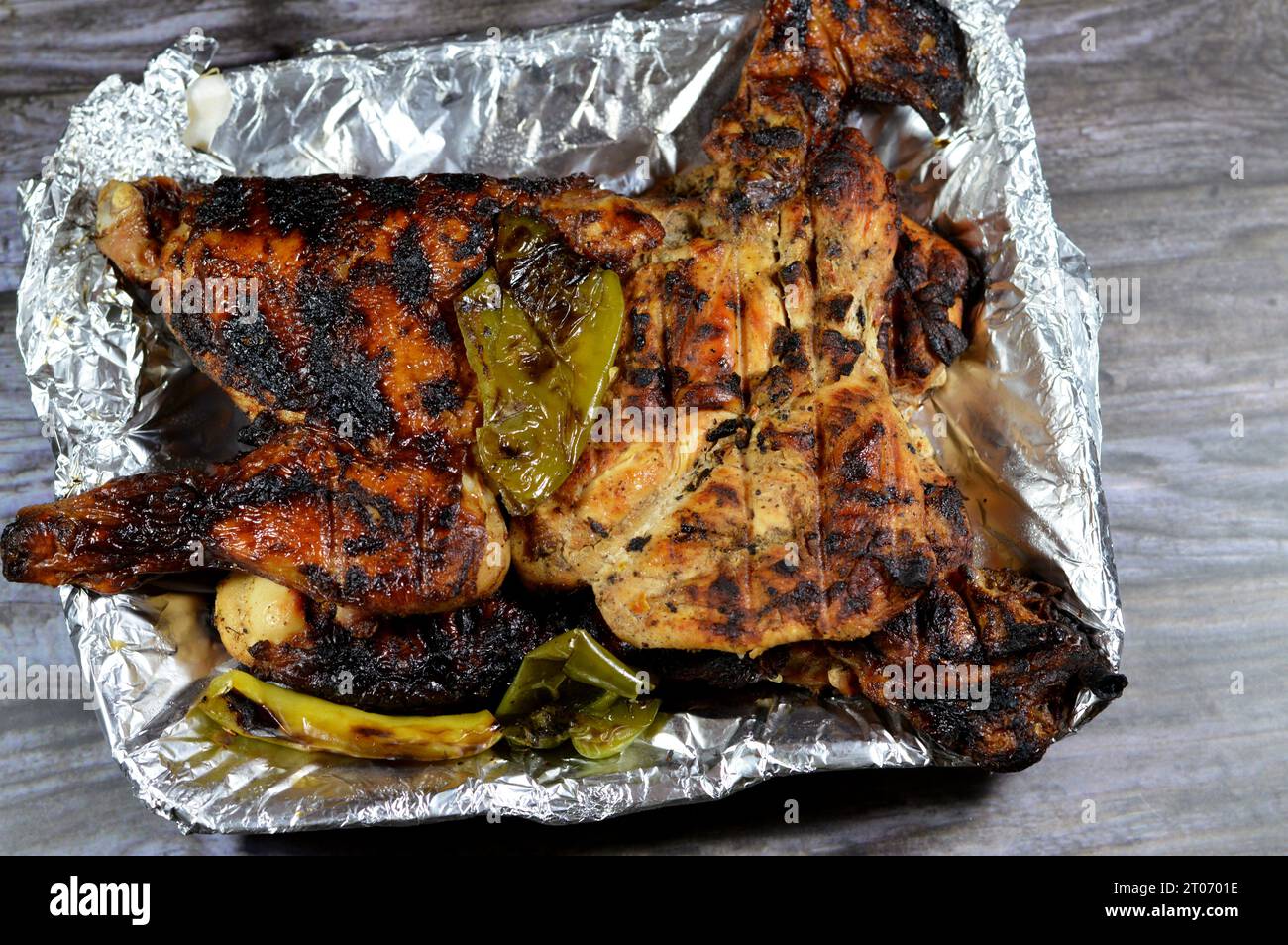 Chicken grilled and roasted on a charcoal grill, served on a disposable ...