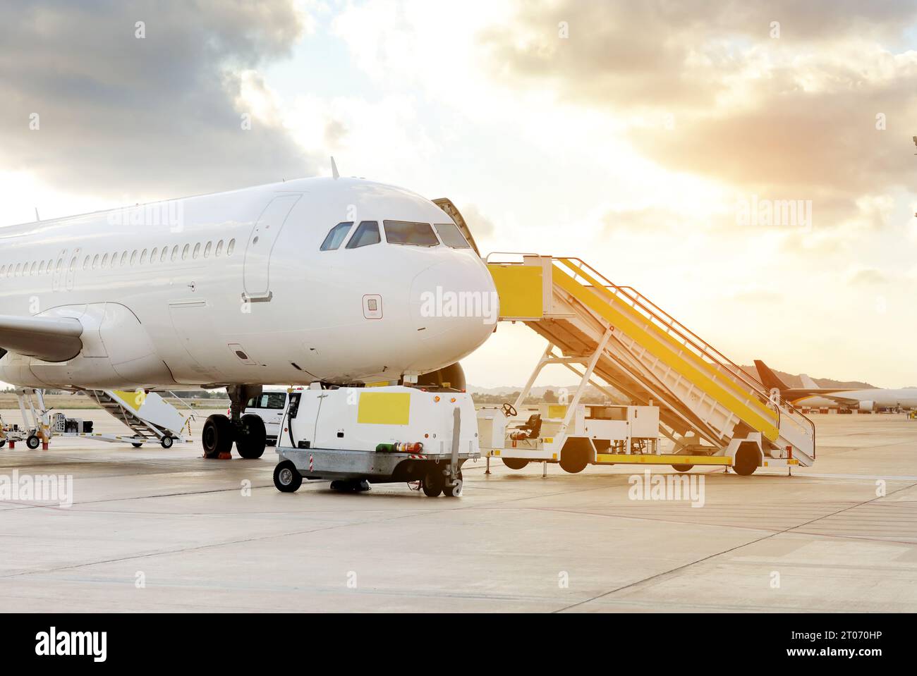 Front view of large white passenger airplane and air-stairs to the door ...