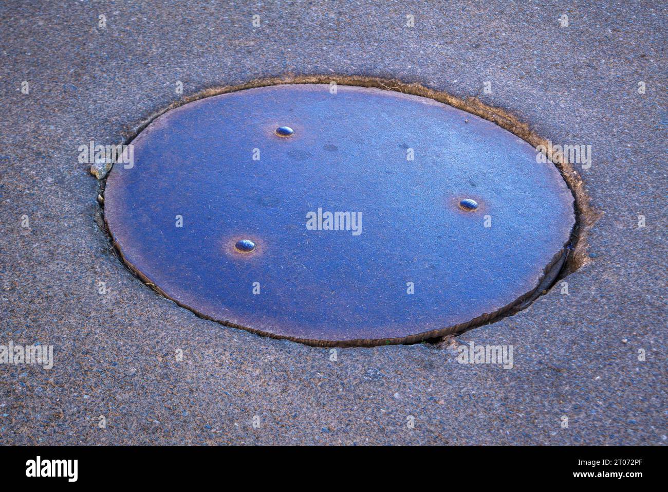 Cast-iron manhole of the storm sewer system on the road in front of the ...
