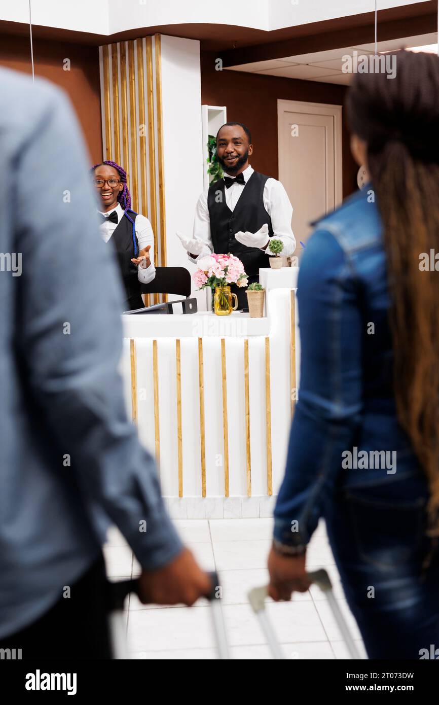 Positive friendly African American front desk staff welcoming greeting ...