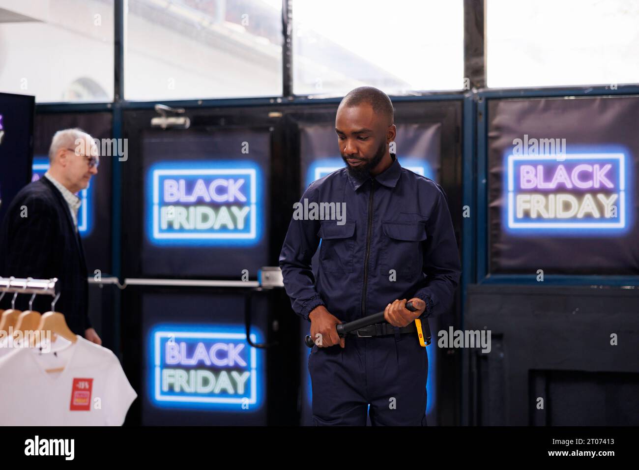 Retail security patrol guard wearing uniform patrolling fashion store ...