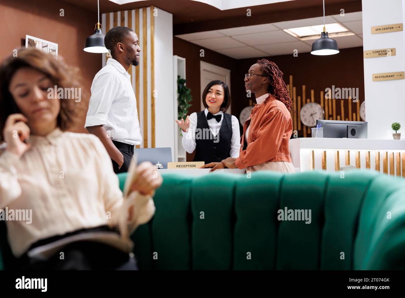 Asian hotel staff welcoming guests in lobby, providing excellent ...