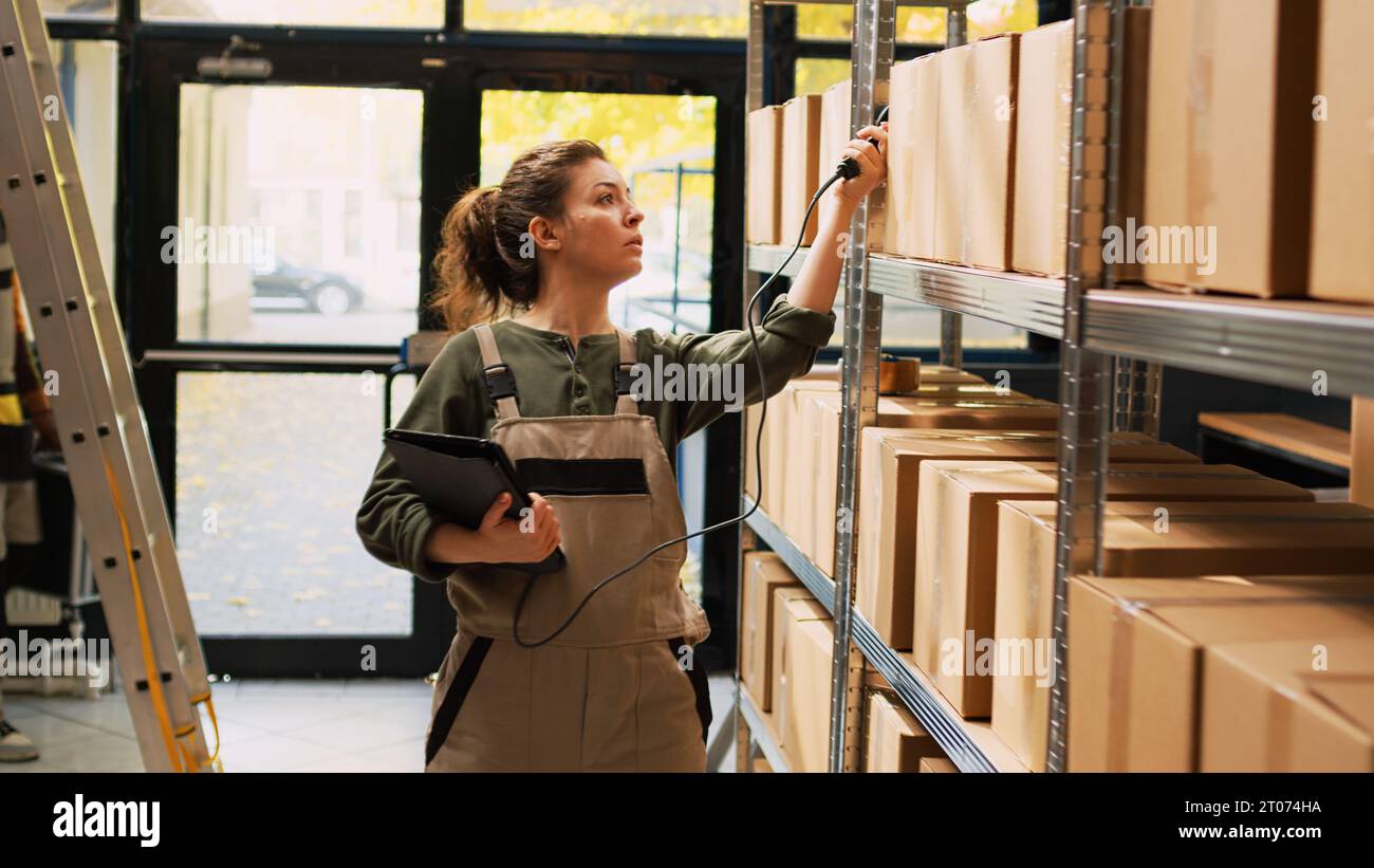 Stock room employee scanning barcodes using tablet scanner for ...