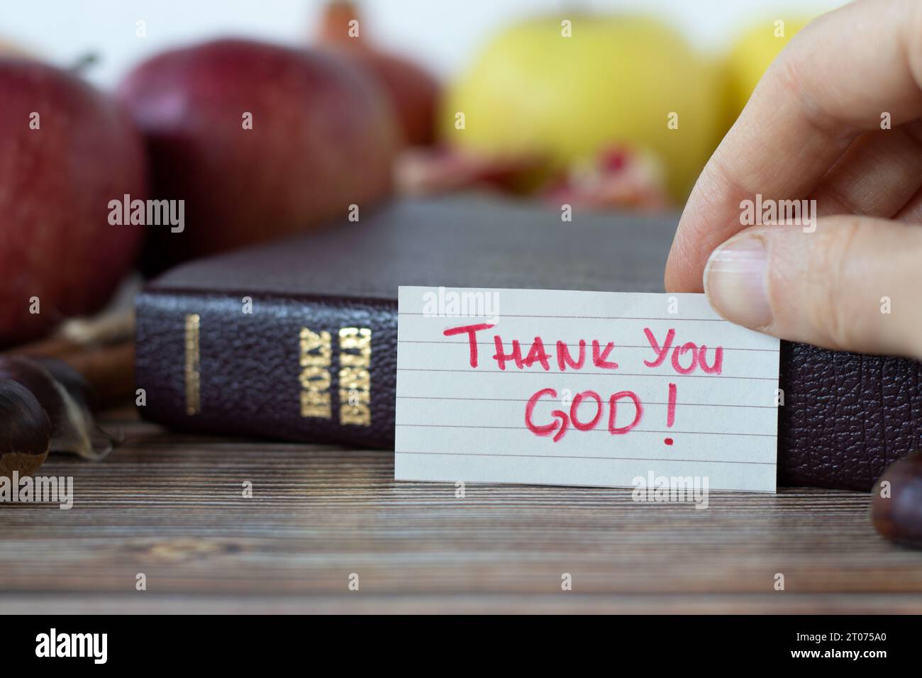 Hand holding a handwritten note: "Thank You God" with Holy Bible book ...