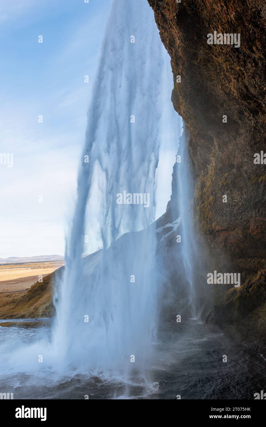 Inside arctic skgafoss waterfall with river stream frunning down off ...