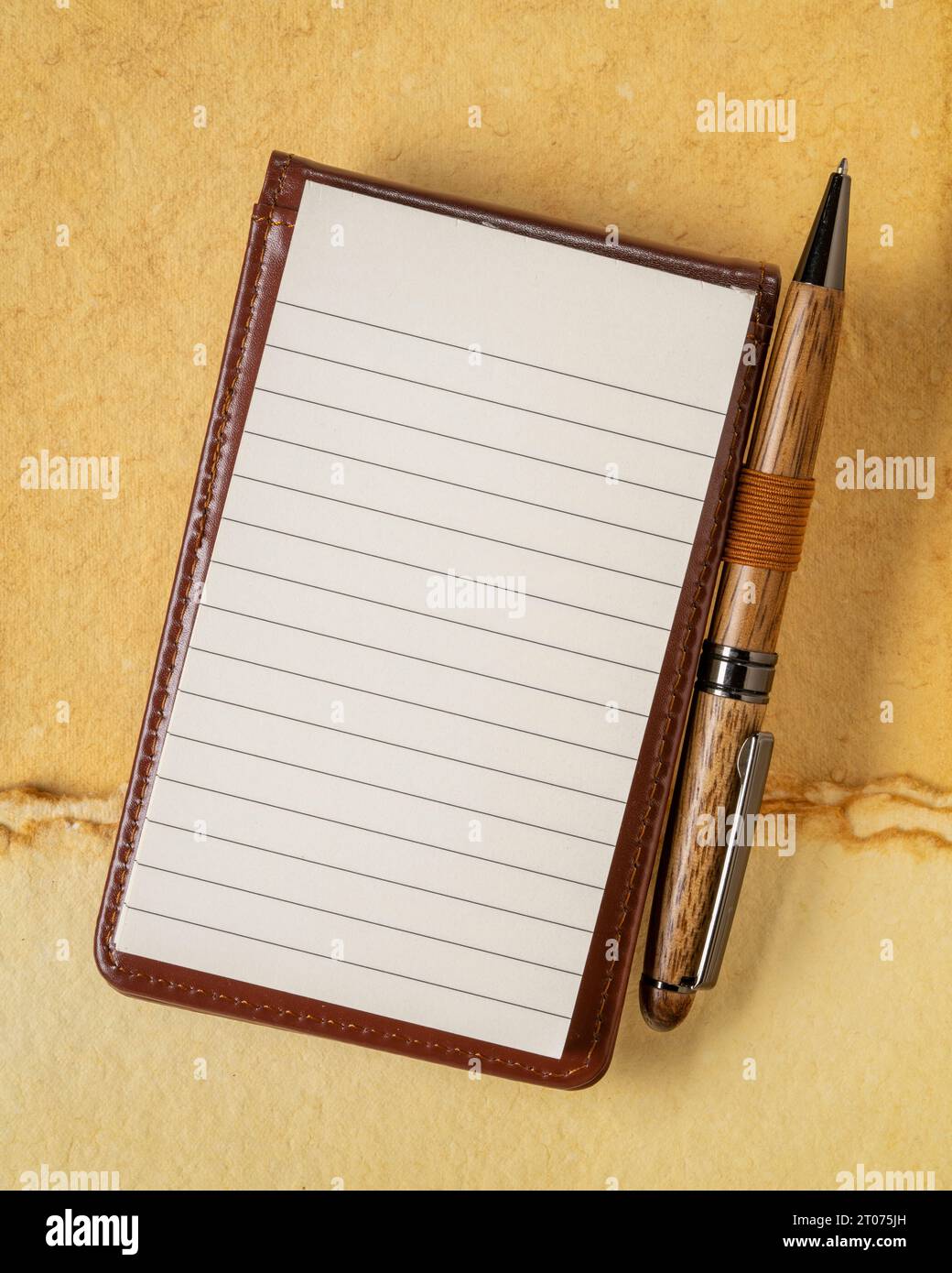 blank sheet of ruled paper in a small journal with a luxury pen against ...