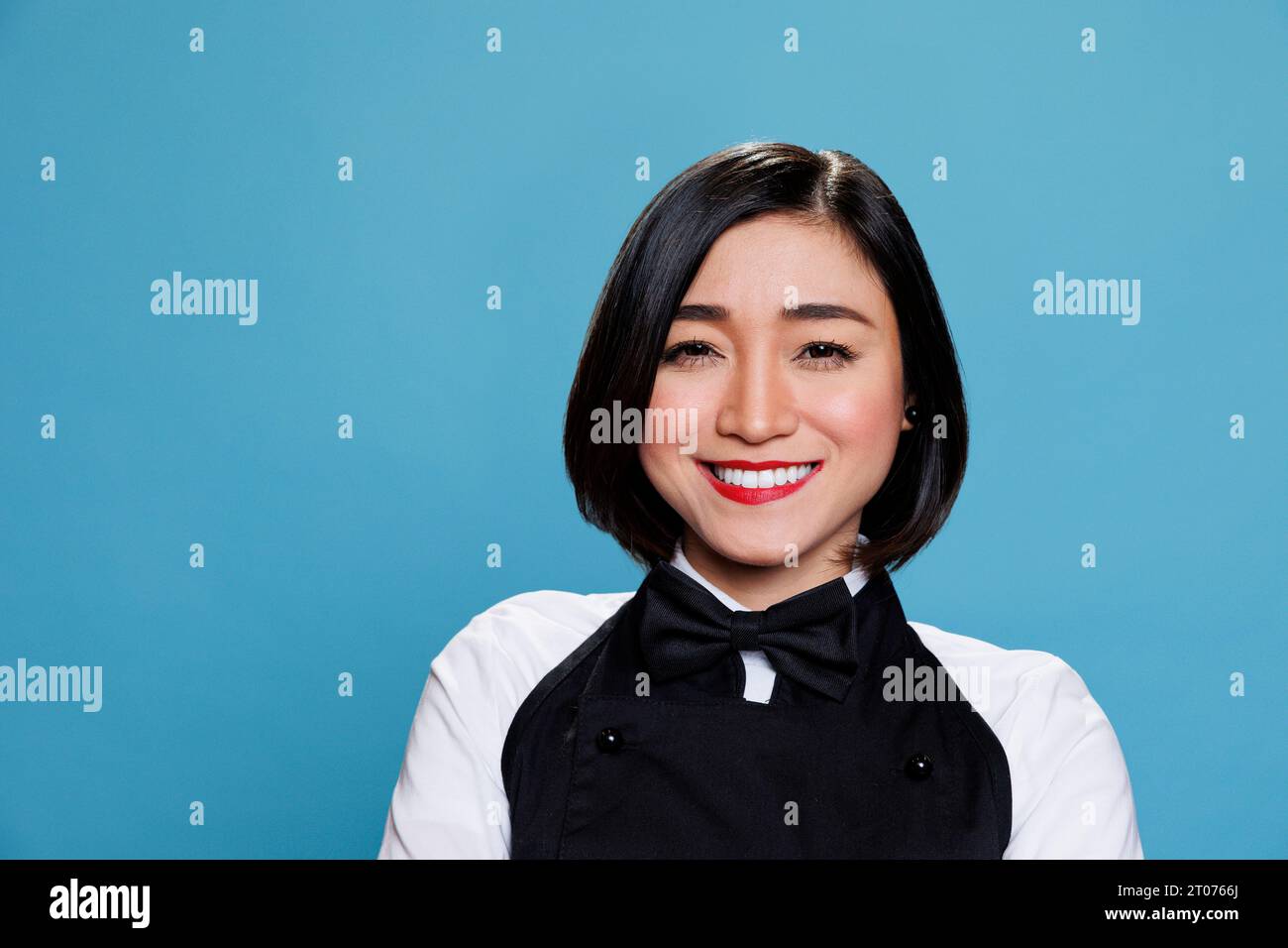 Smiling happy young asian waitress looking at camera with positive ...