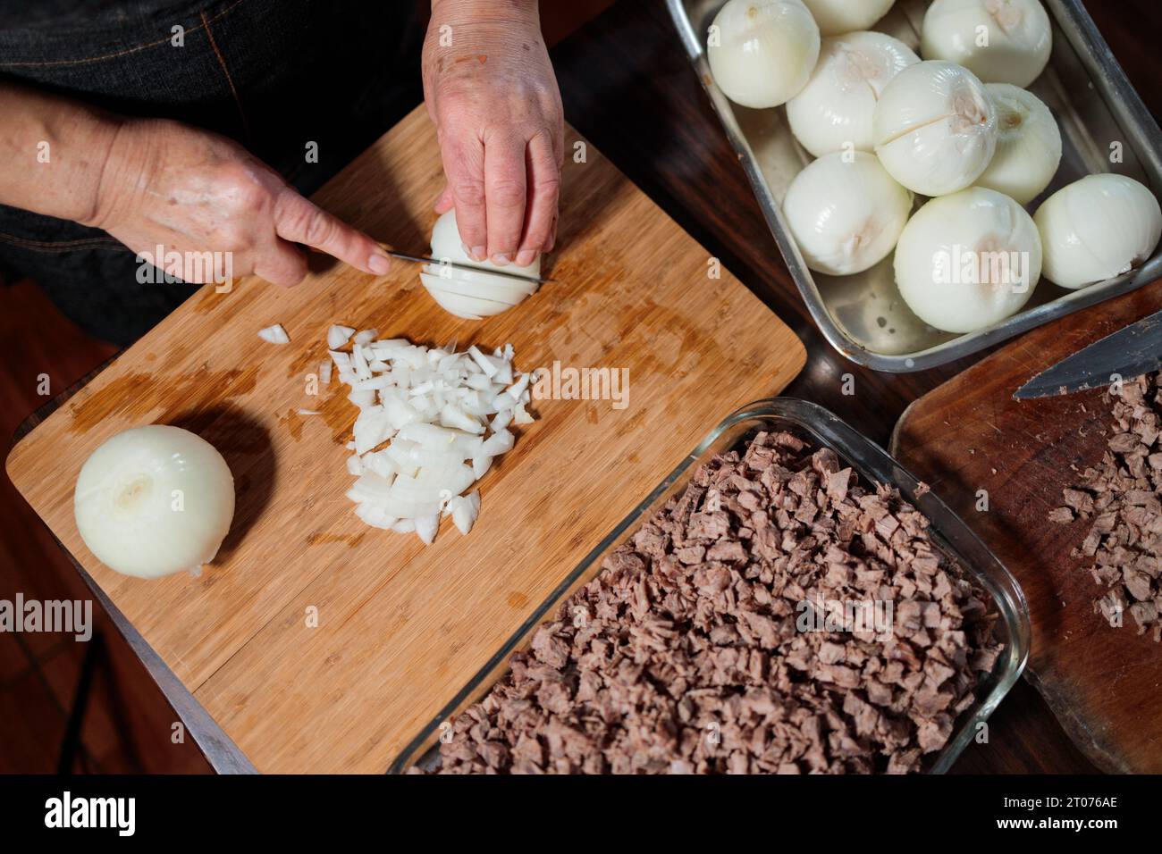 Top view of unrecognizable latin woman chopping onion and meat for ...