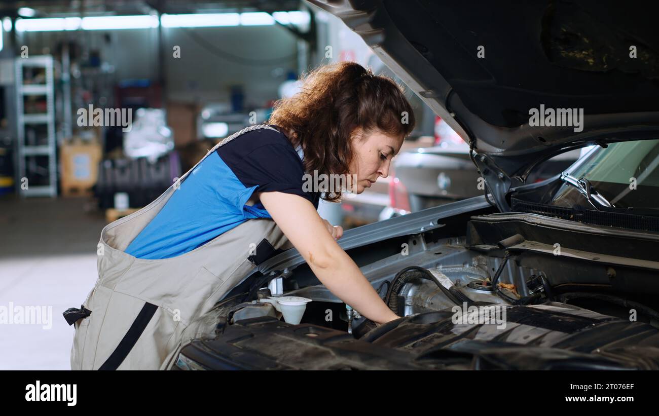 Hardworking mechanic in garage using torque wrench to tighten bolts ...