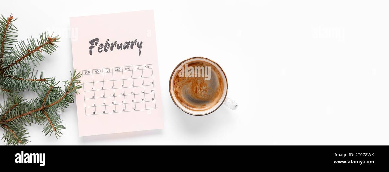 Paper calendar for February with fir branches and cup of coffee on ...