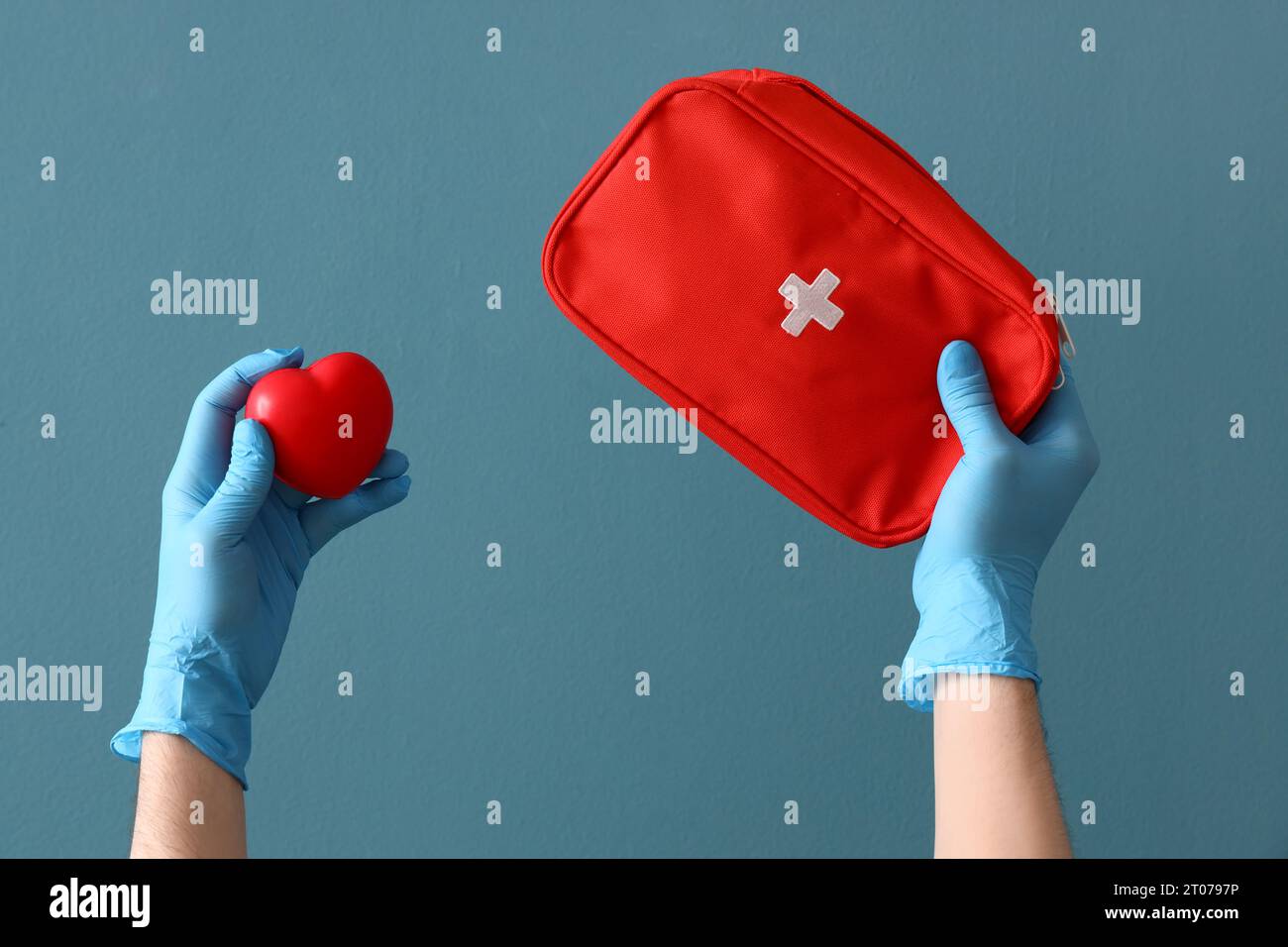 Cardiologist with heart and first aid kit on blue background Stock ...