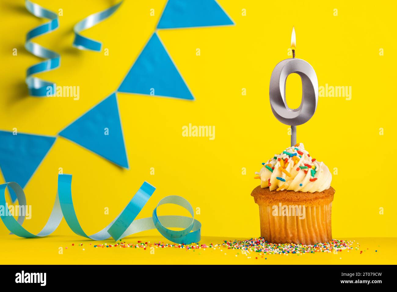 Lighted birthday candle number 0 - Yellow background with blue pennants ...