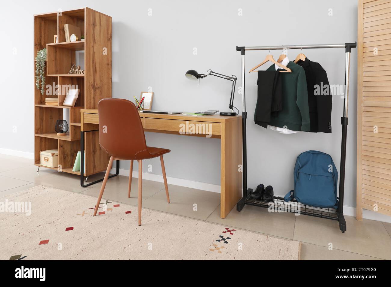 Interior of stylish room with modern workplace and school uniform on ...