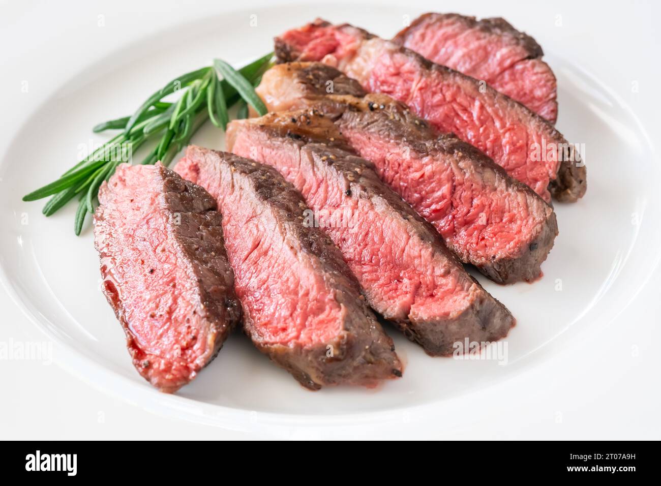 Sliced rib eye steak on white background. Medium rare Stock Photo - Alamy