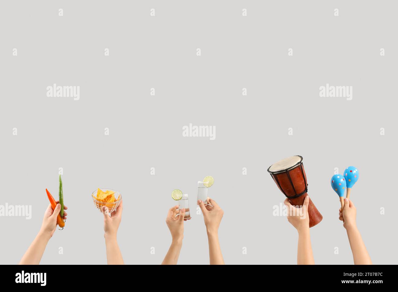 Female hands holding shots of tequila, musical instruments, nachos and ...