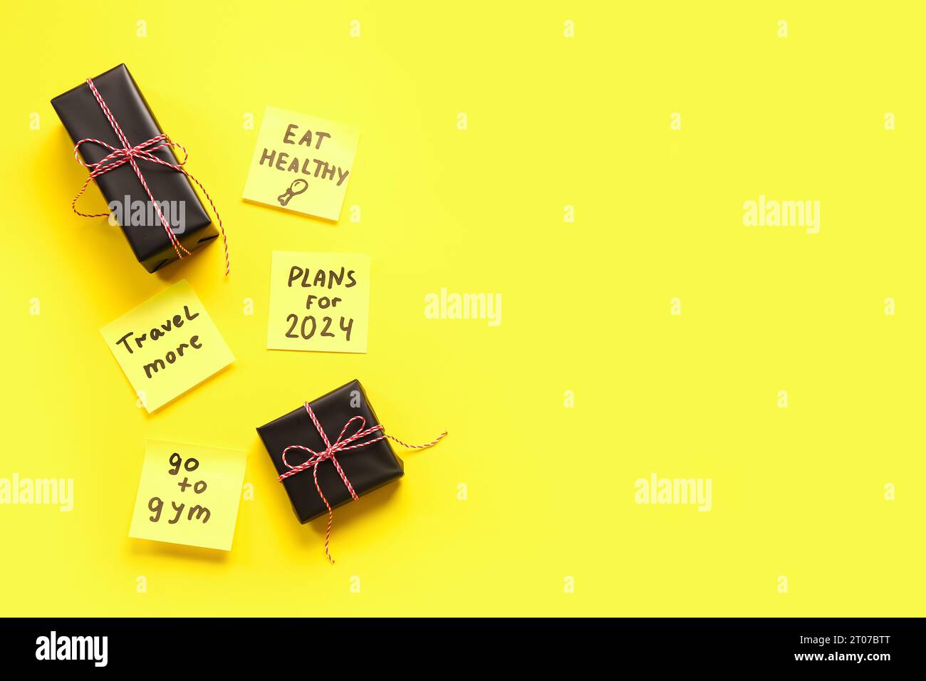 Sticky notes with different goals for 2024 and gift boxes on yellow ...