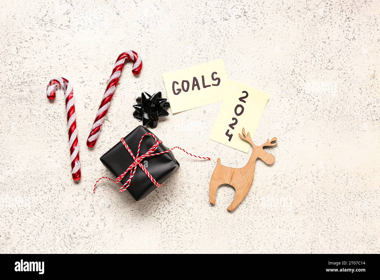 Sticky notes with goals for 2024, gift box and Christmas decorations on ...