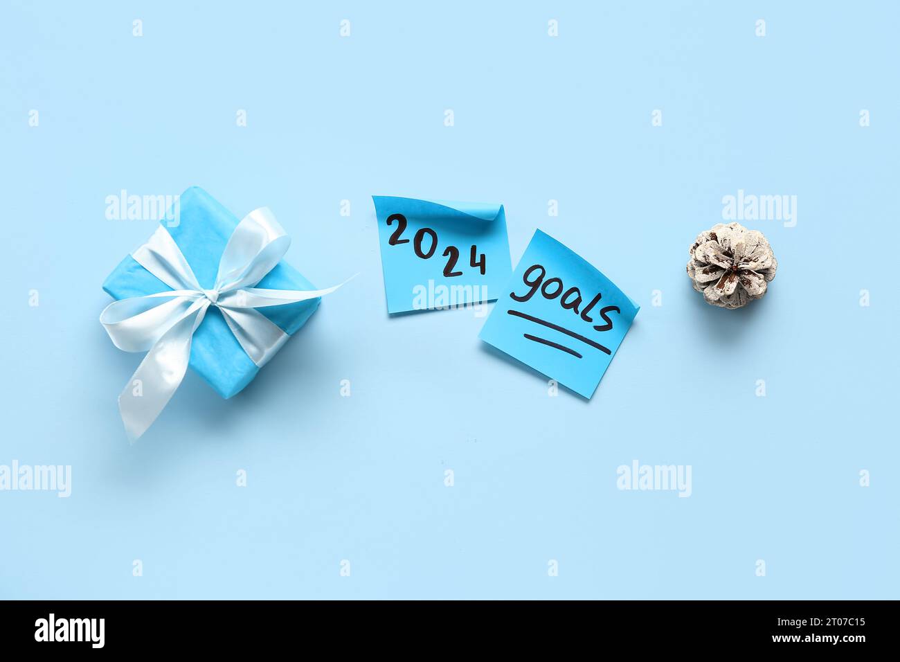Sticky notes with goals for 2024, gift box and forest bump on blue ...