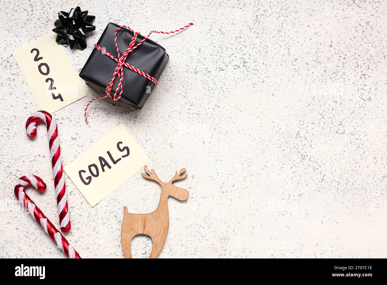 Sticky notes with goals for 2024, gift box and Christmas decorations on ...