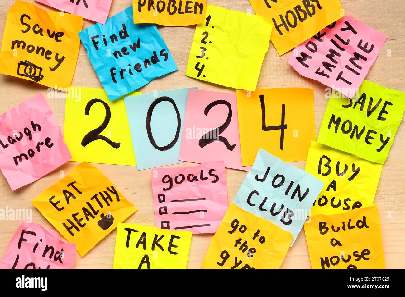 Sticky notes with different goals for 2024 on beige wooden background ...